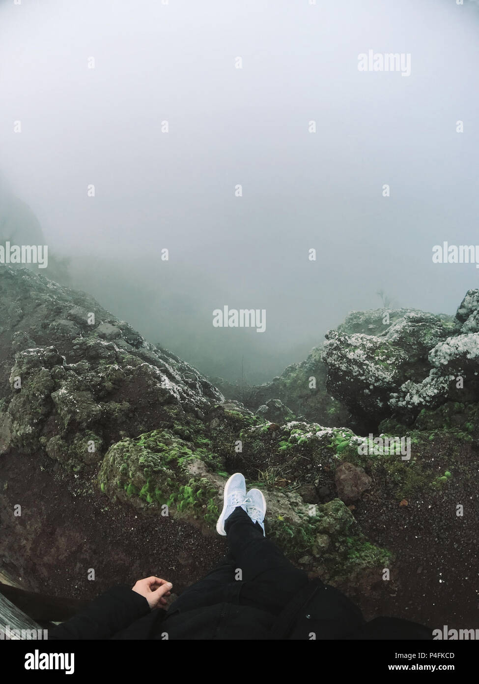 Man on cliff look at the fog Stock Photo - Alamy