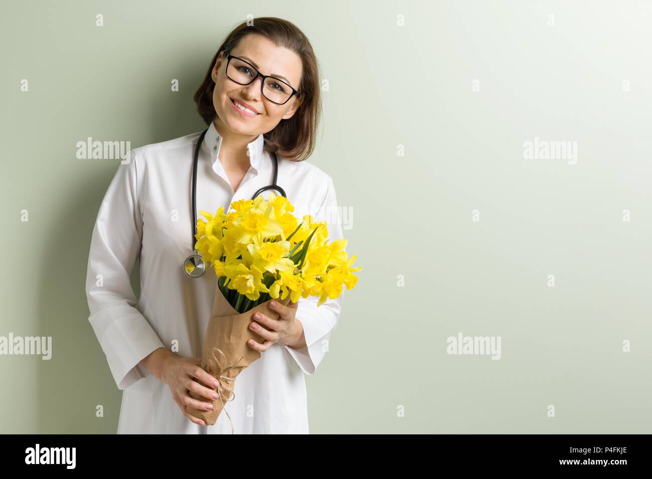 Smiling woman doctor with bouquet of flowers. World health day, doctors ...