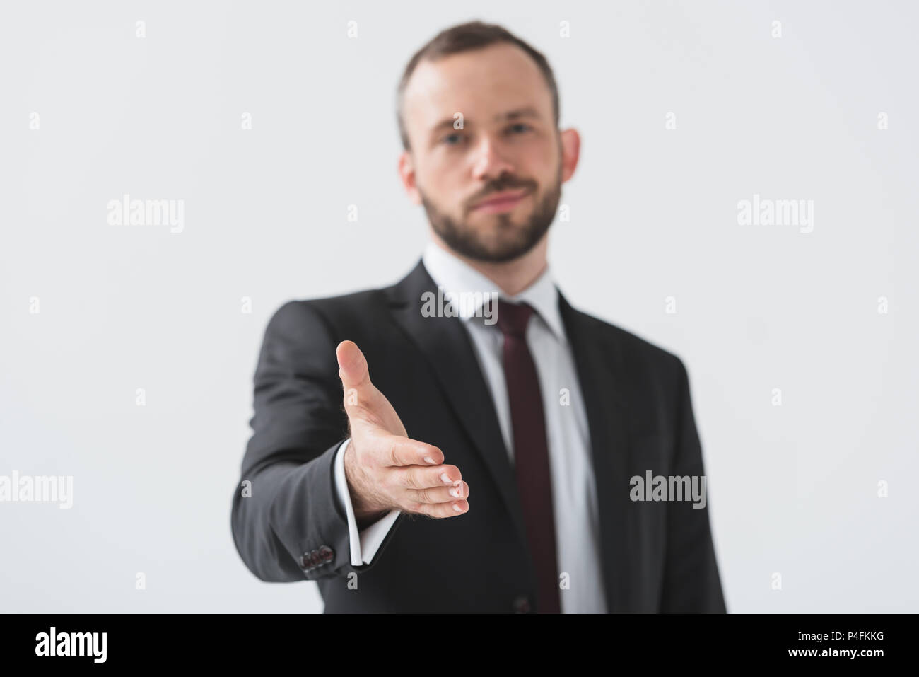 selective focus of smiling businessman with outstretched hand isolated ...