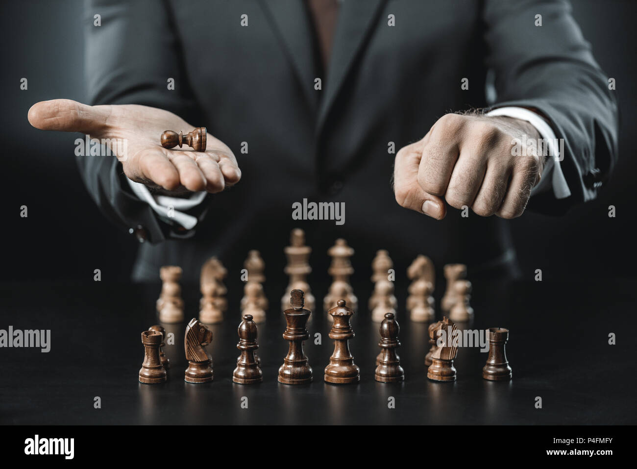 partial view of businessman in suit holding chess figure in hand Stock ...
