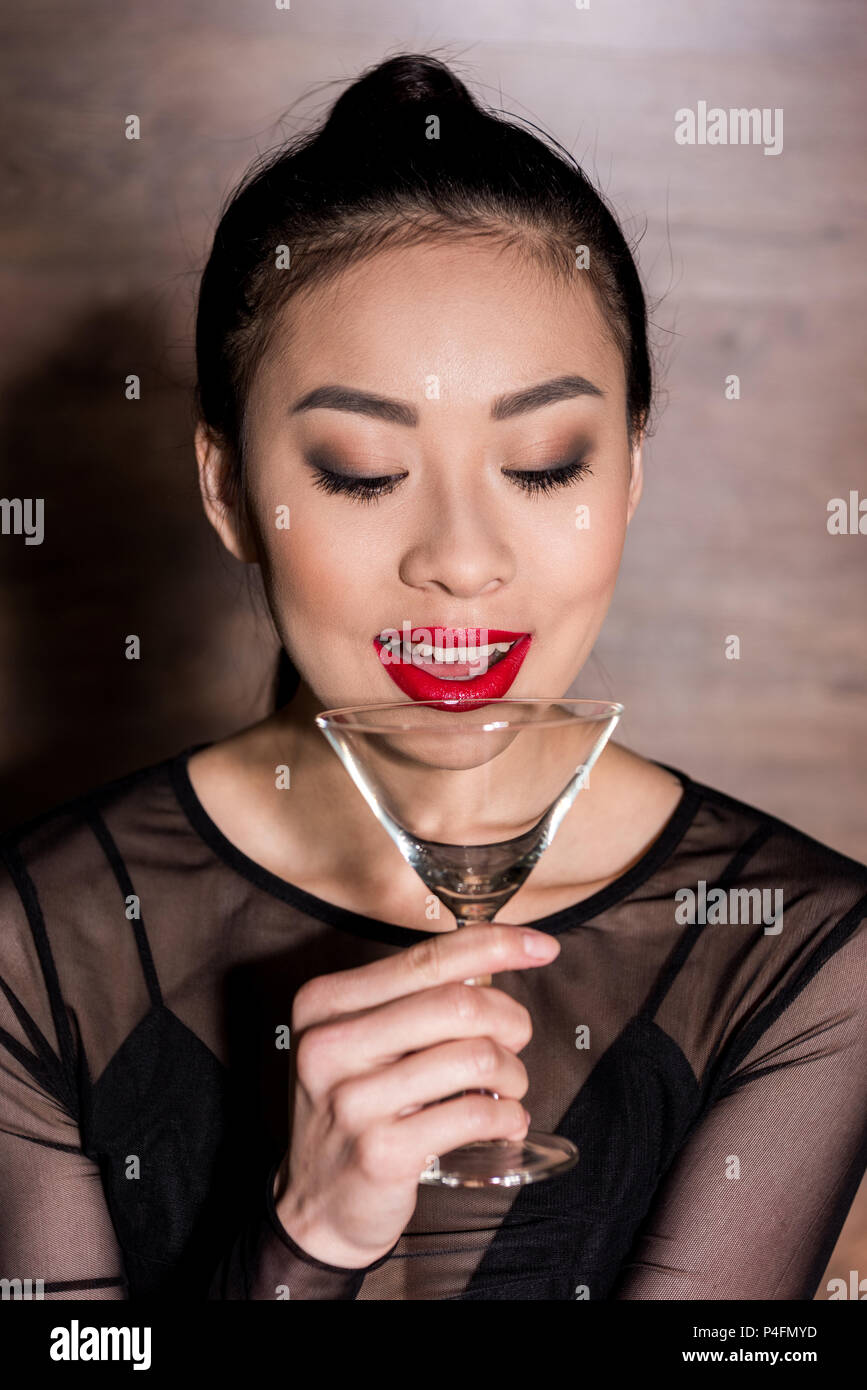 portrait of beautiful asian woman drinking martini from martini glass ...