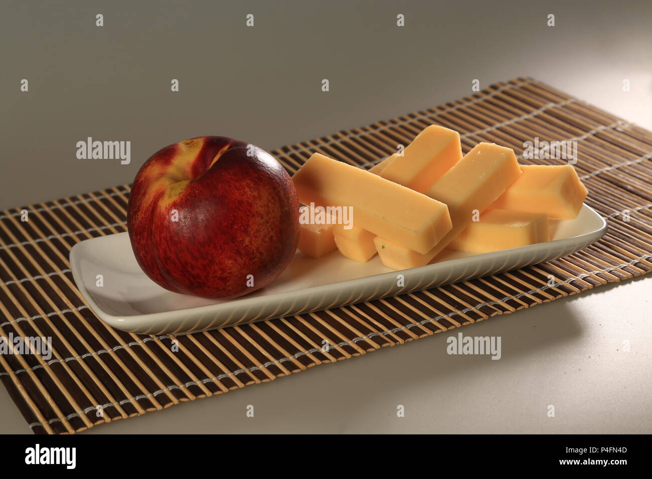 Slices of cheese with a peach on the side in a plate Stock Photo - Alamy