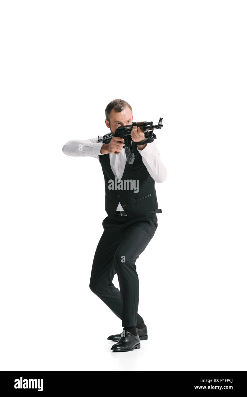 secret agent in suit with rifle aiming away isolated on white Stock ...