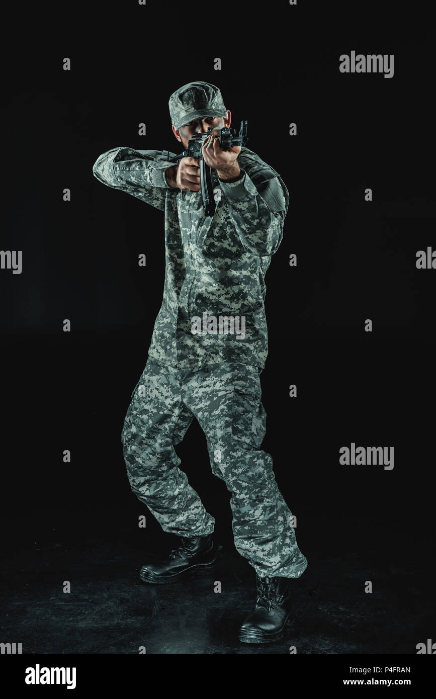 soldier in military uniform with rifle aiming isolated on black Stock ...
