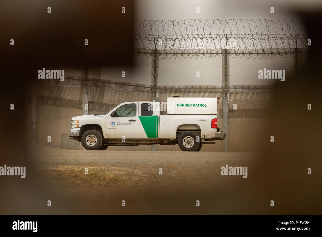 A US Border Patrol vehicle keeps watch of the USA and Mexican border ...