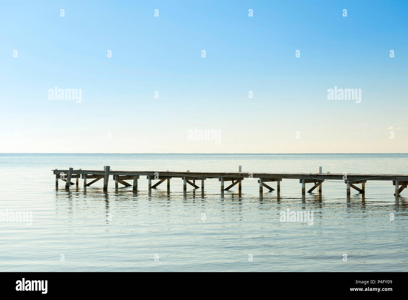 Wooden dock over calm ocean water as minimalism background Stock Photo ...