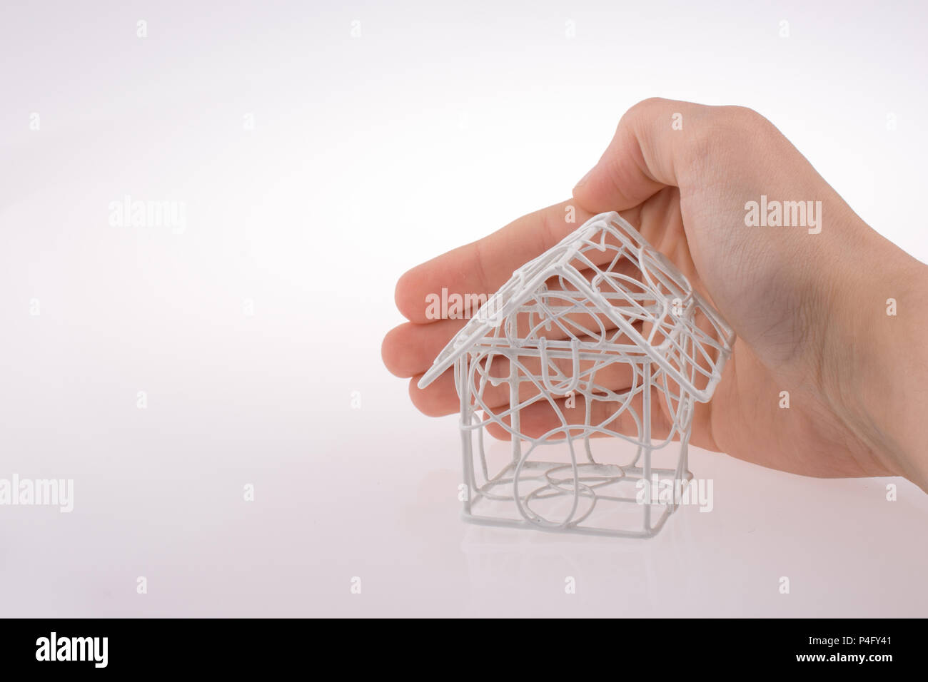 Little model house made of white metal wire in hand Stock Photo - Alamy