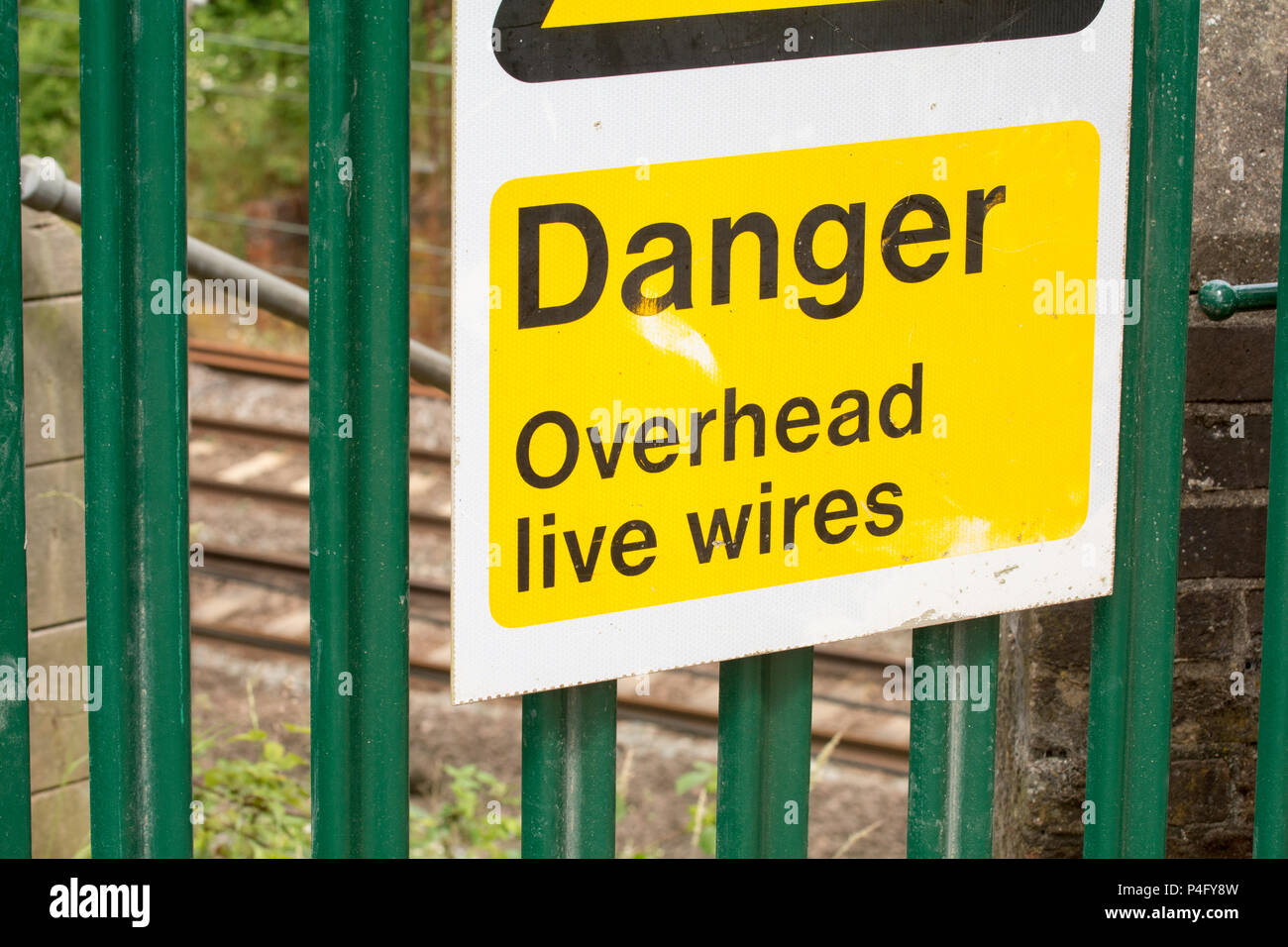Warning sign of live wires on the railway track Stock Photo - Alamy