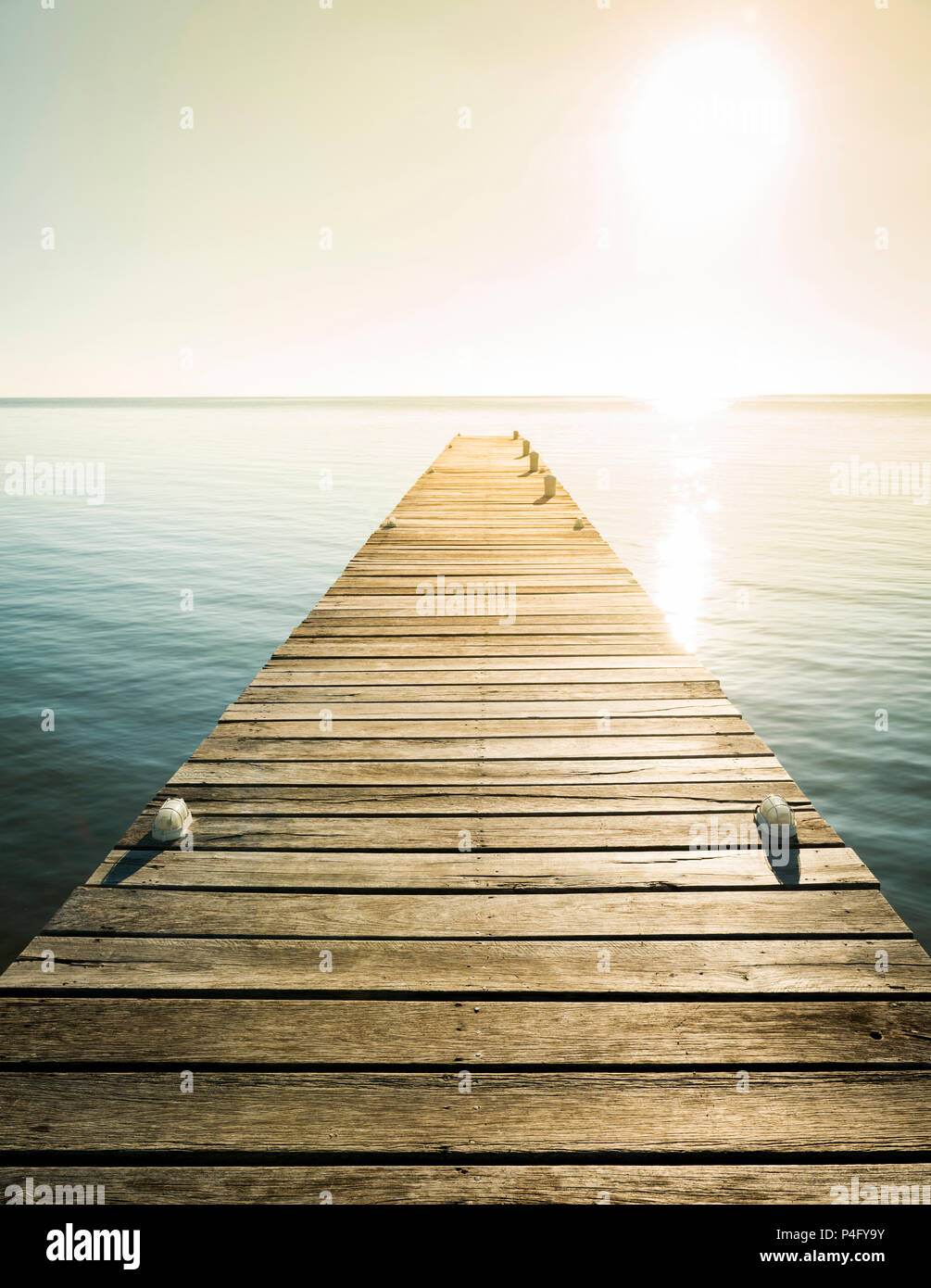 Wooden jetty with golden light as background Stock Photo - Alamy