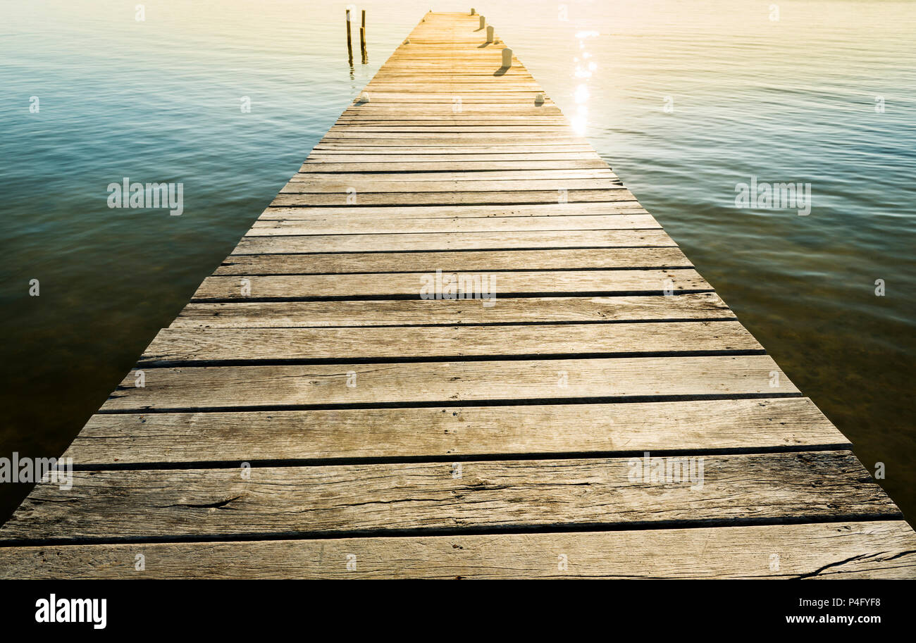 Wooden jetty with golden light as background Stock Photo - Alamy