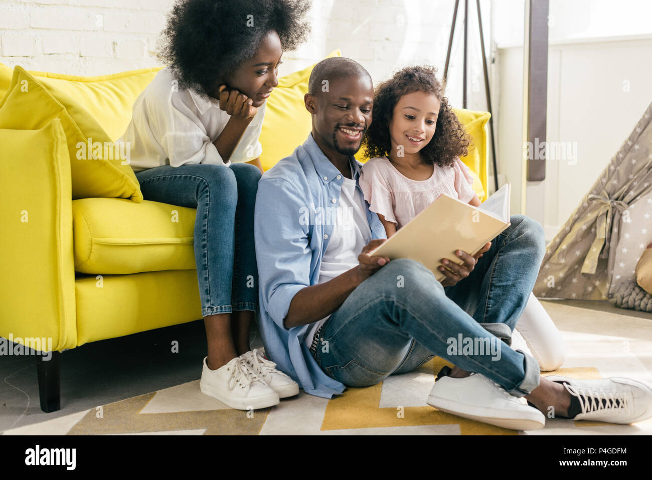 happy african american family reading book together at home Stock Photo ...