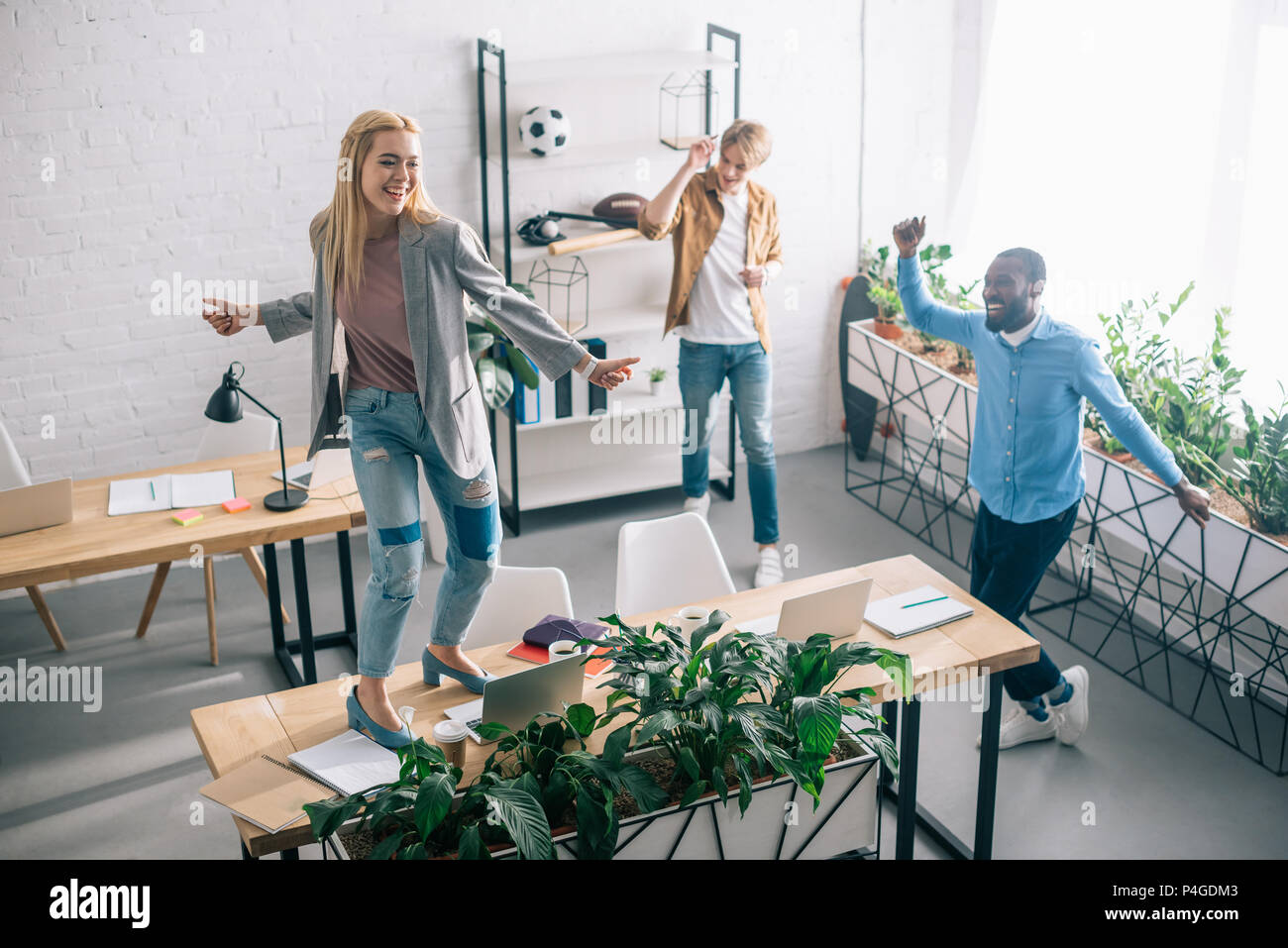 high angle view of happy multiethnic business colleagues dancing and ...