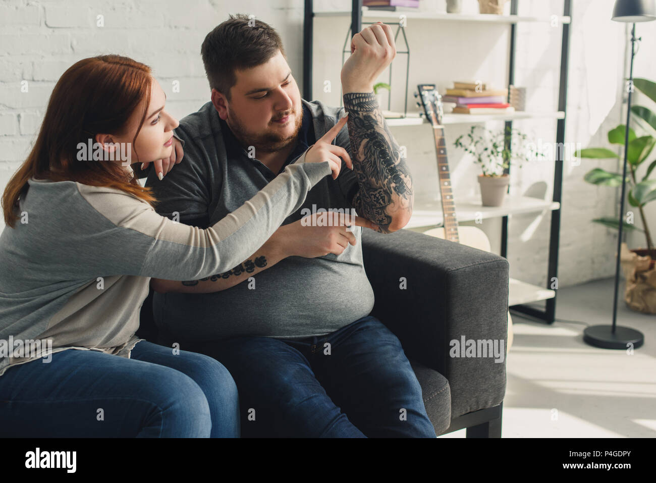 girlfriend touching boyfriend tattoos at home Stock Photo - Alamy