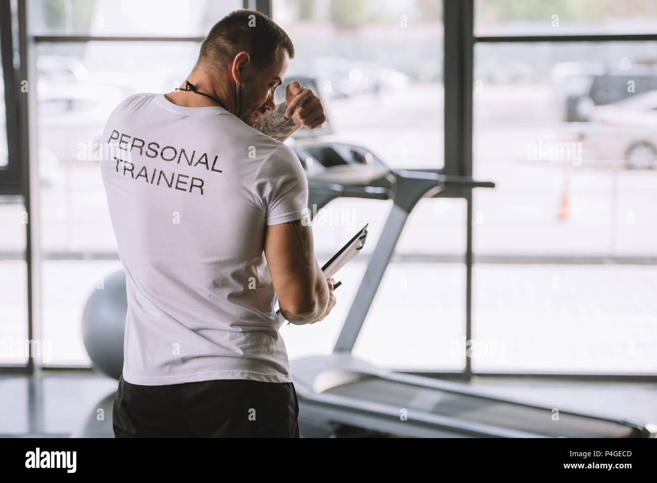 man with clipboard pointing on back of t-shirt with lettering personal ...