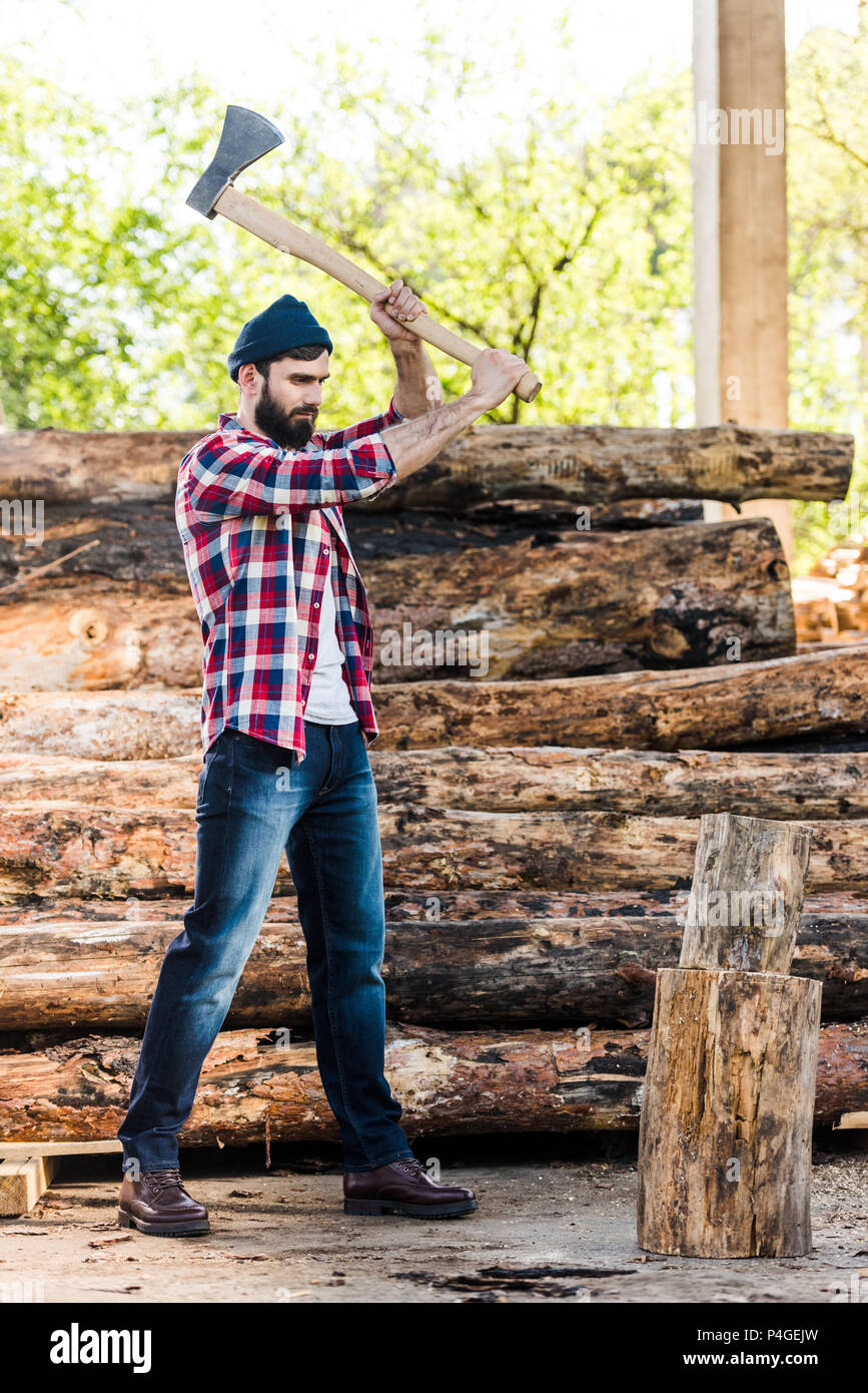 lumberjack in checkered shirt chopping log at sawmill Stock Photo - Alamy