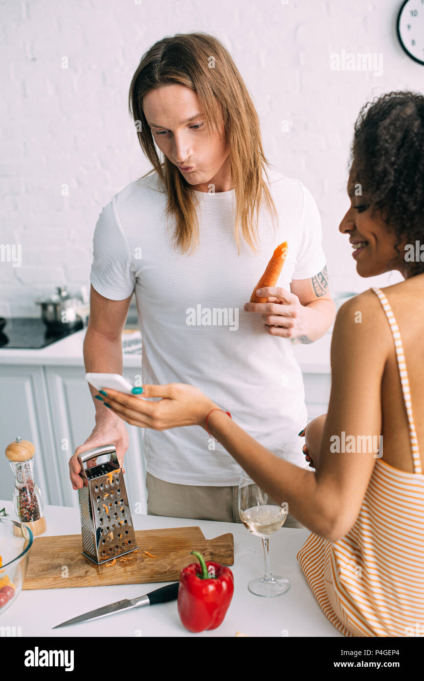 smiling african american woman showing recipe on smartphone to ...