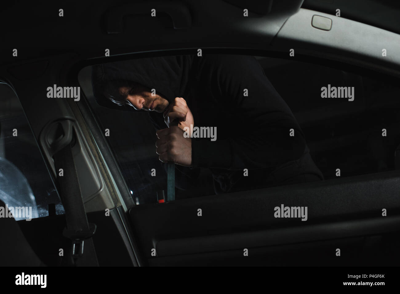 male mugger in black hoodie intruding car by crowbar Stock Photo - Alamy