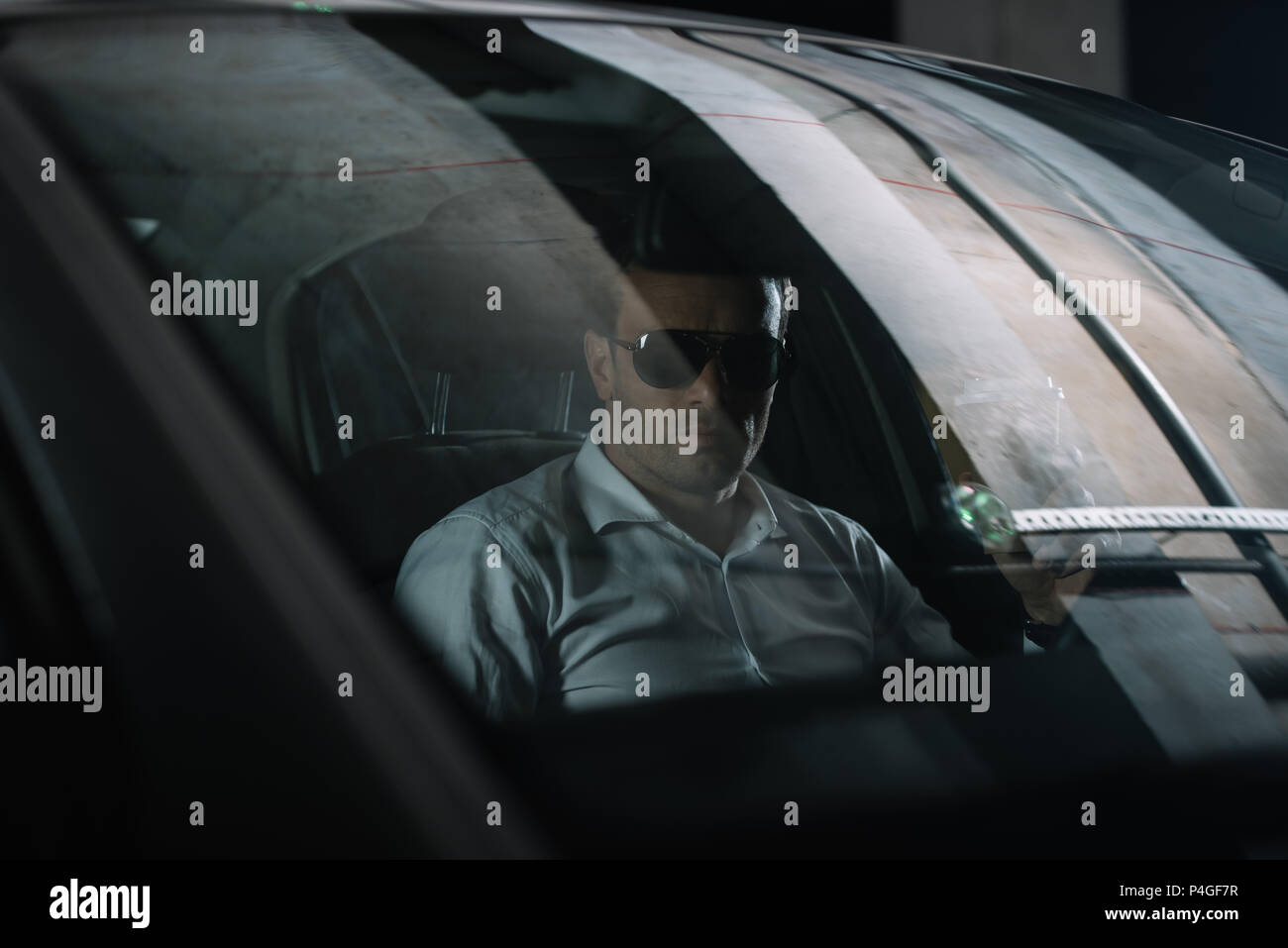male undercover agent in sunglasses sitting in car with paper cup of ...
