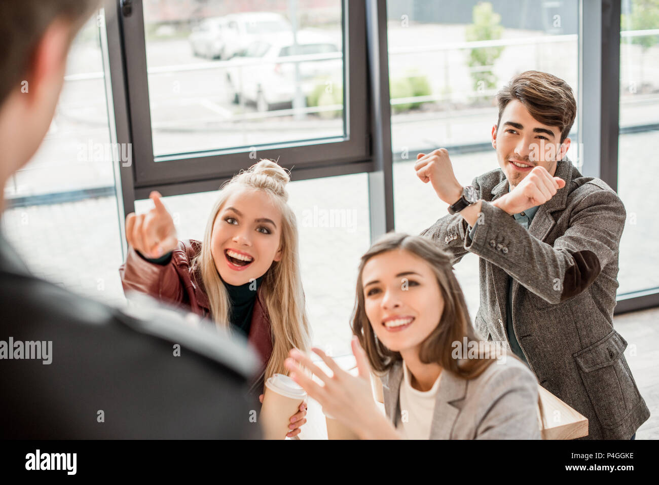 Three friends looking at friend and showing different gestures Stock ...