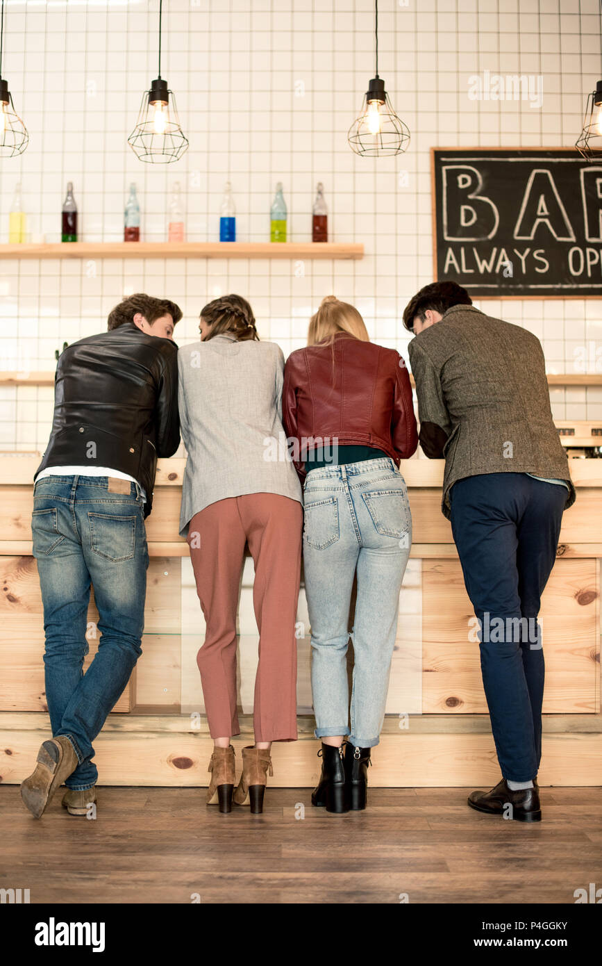 Rear view of people standing at the wooden bar counter Stock Photo - Alamy