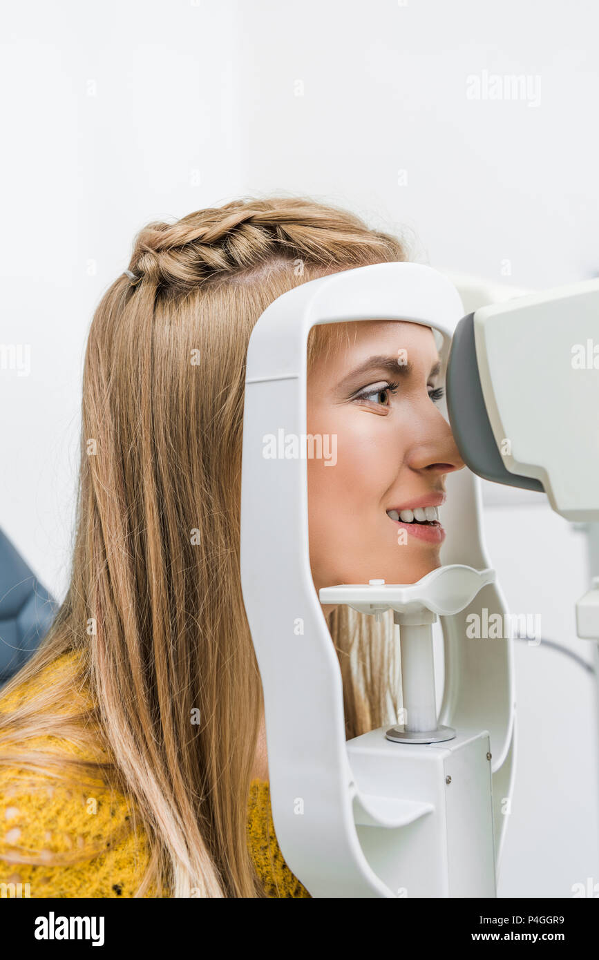 smiling patient examining her eyes with slit lamp in clinic Stock Photo ...