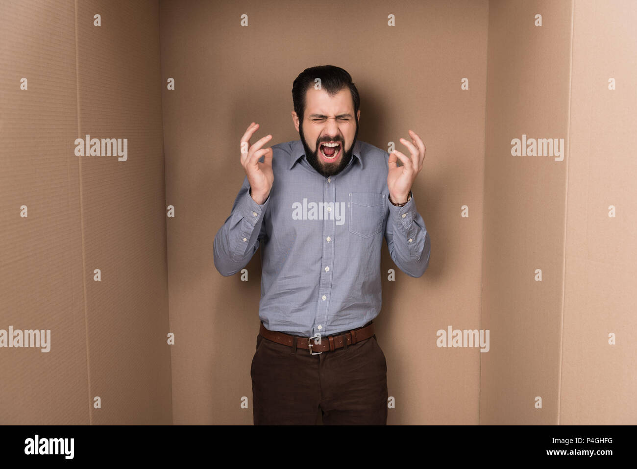 stressed man screaming in cardboard box Stock Photo - Alamy