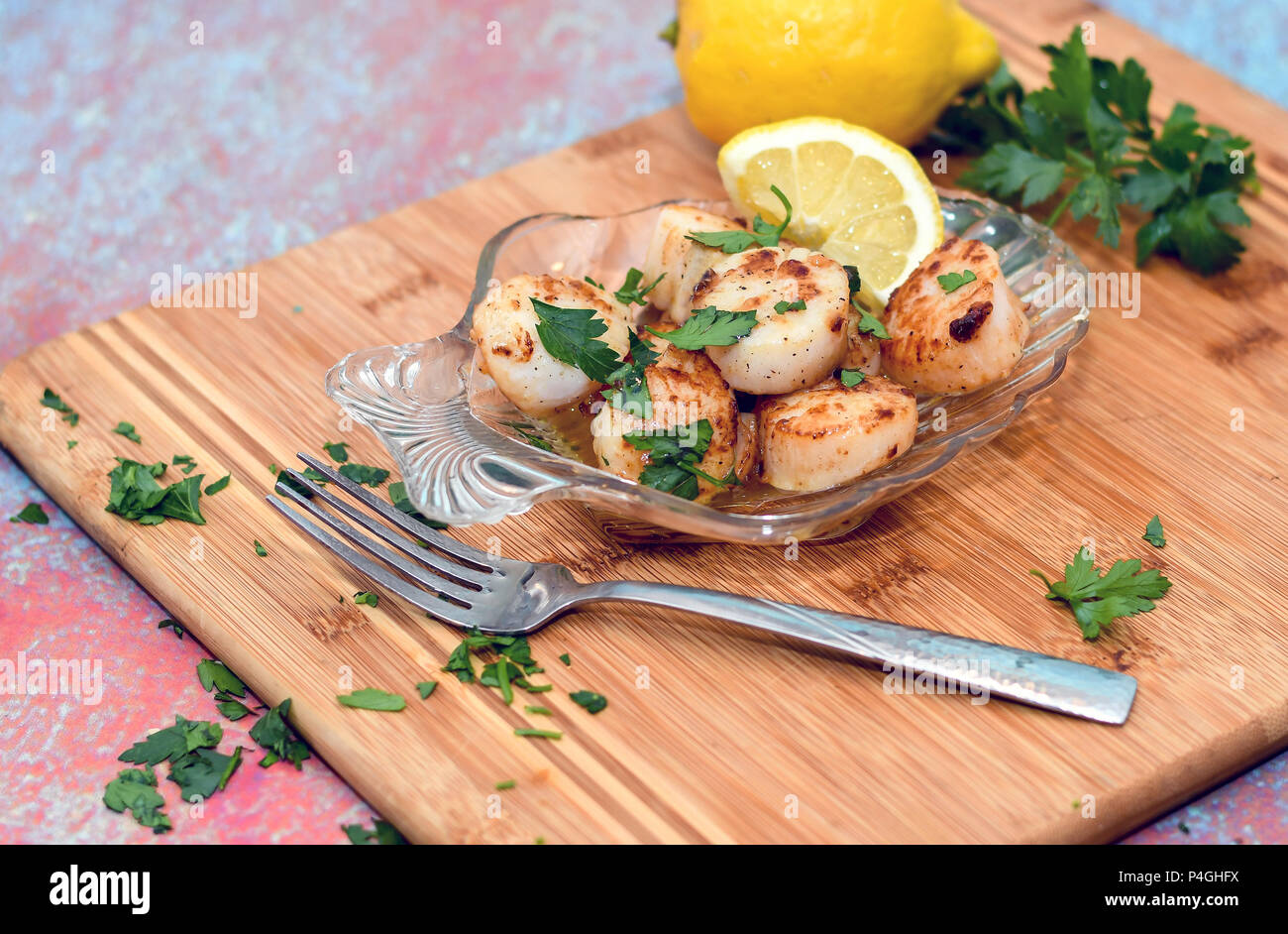 Glass shell plate filled with seared scallops Stock Photo - Alamy
