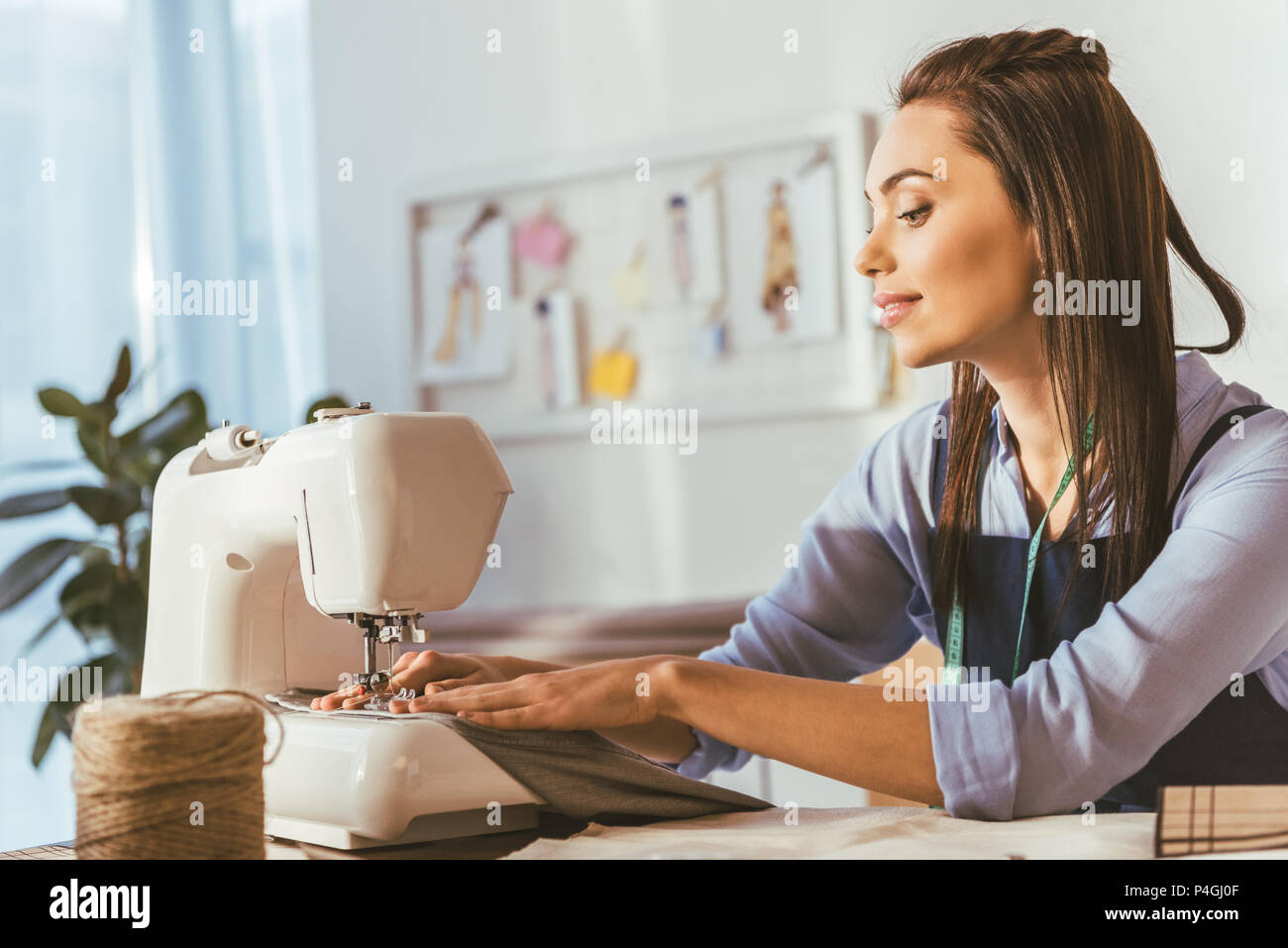 beautiful seamstress sewing with sewing machine Stock Photo - Alamy