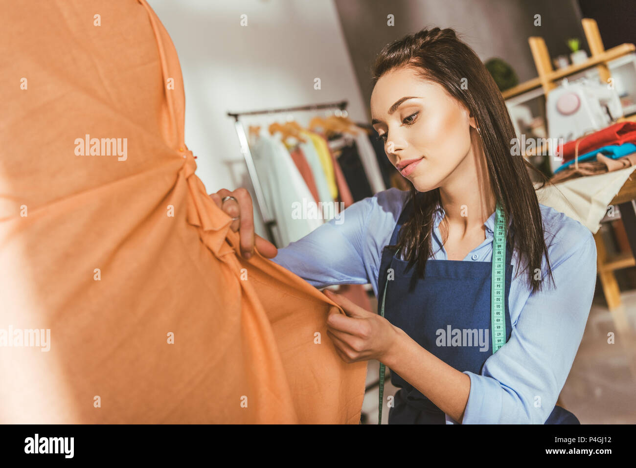 attractive tailor making dress on mannequin Stock Photo - Alamy