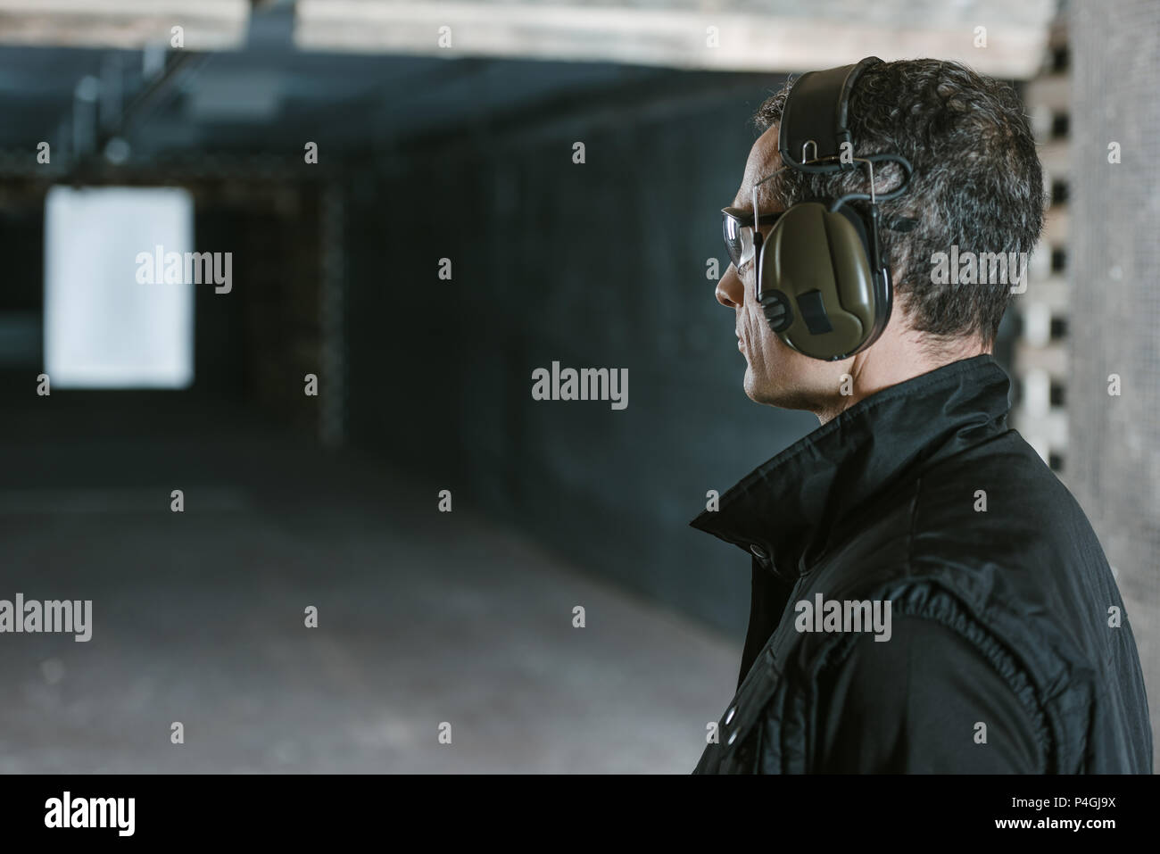side view of handsome man looking at target in shooting range Stock ...