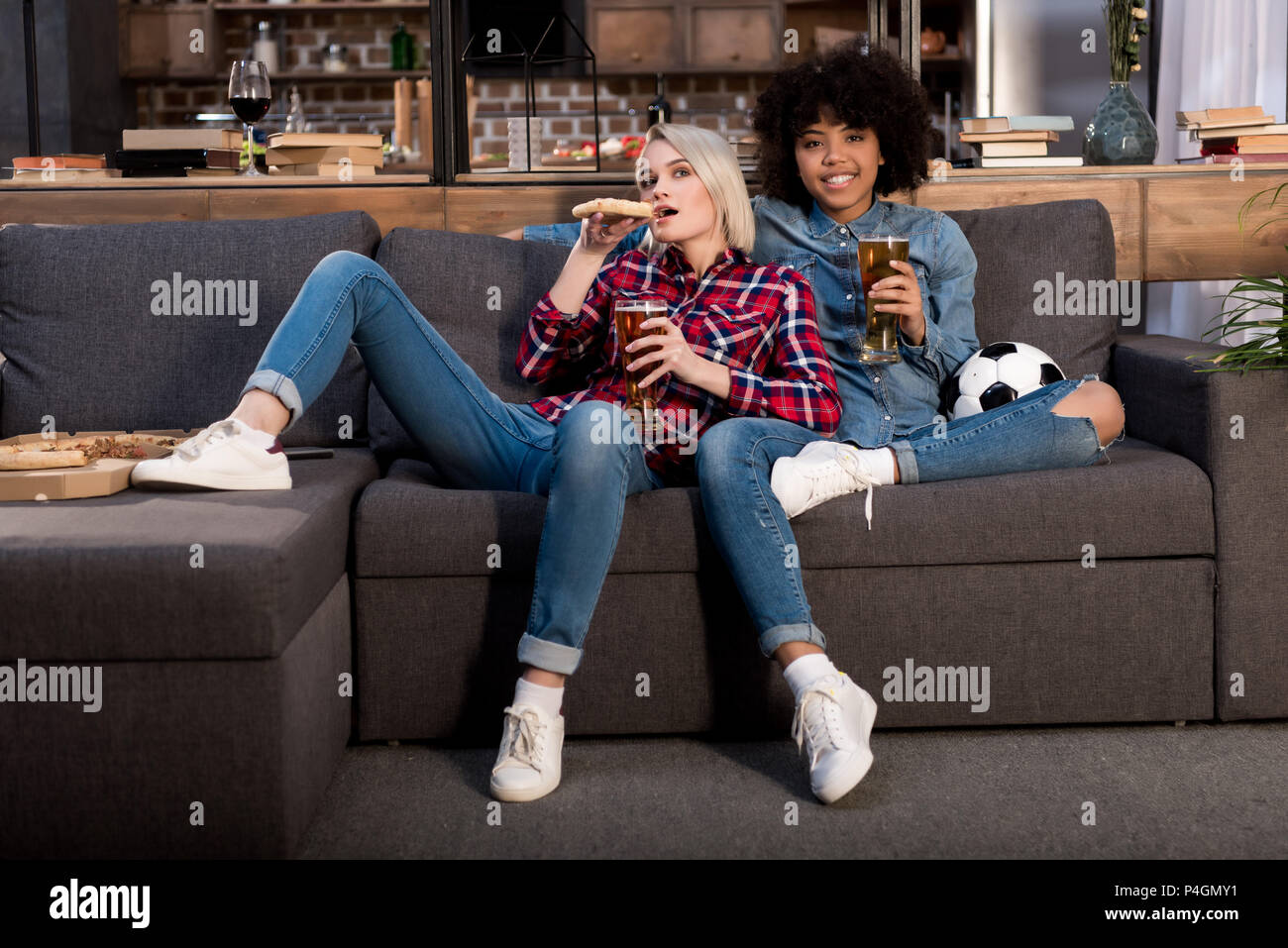 multicultural girls watching football on tv with beer Stock Photo - Alamy