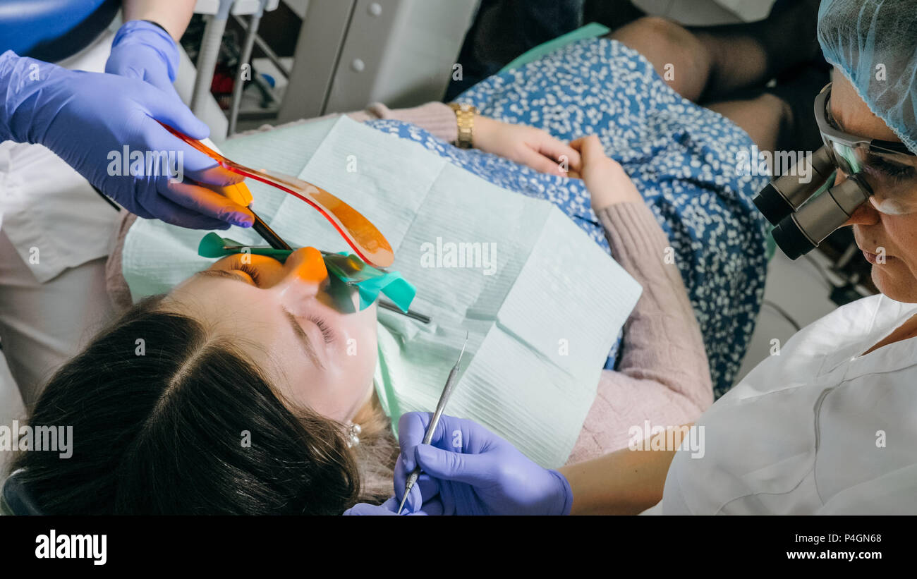 Woman at dentist clinic gets dental treatment to fill a cavity in a ...