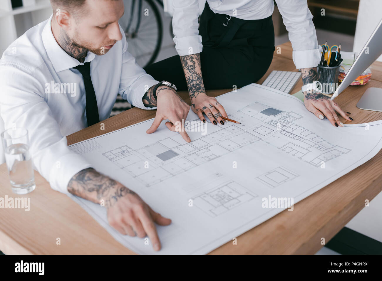 cropped shot of young business people working with blueprint in office ...