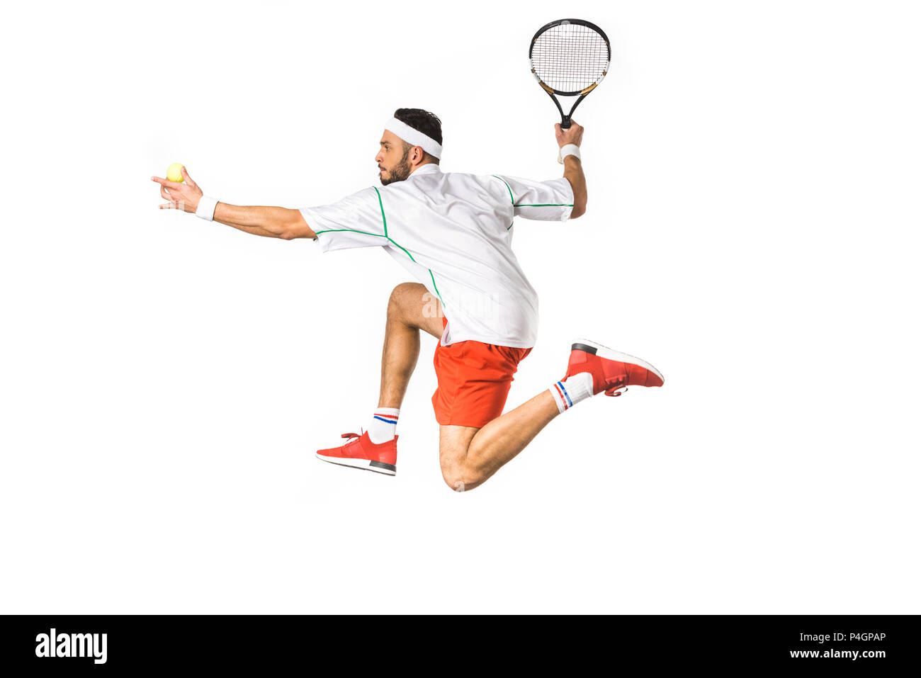 side view of young sportsman with ball and racket playing tennis ...