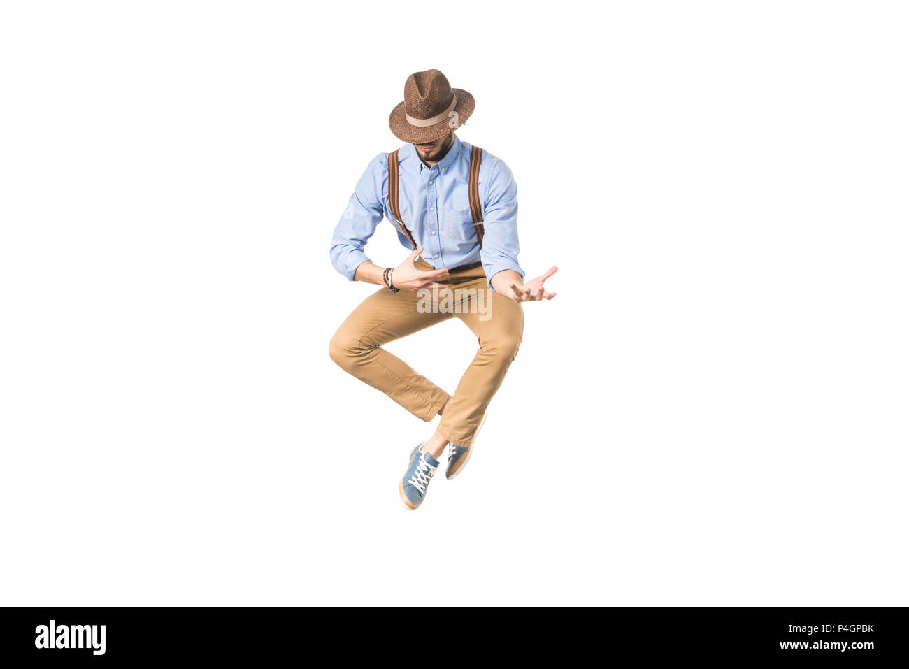 stylish young man in hat jumping and gesturing with hands isolated on ...