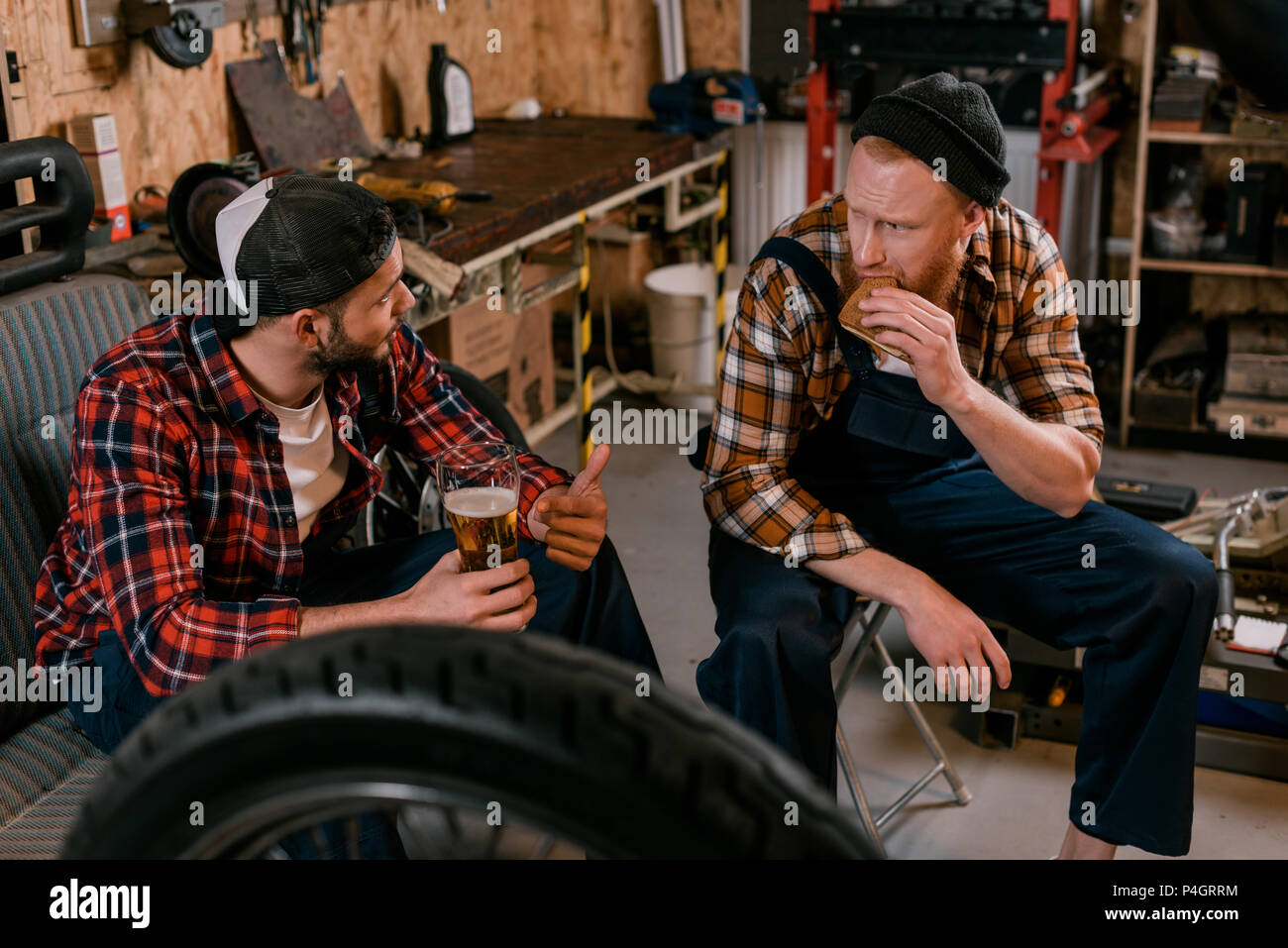 mechanics drinking beer and having lunch at garage Stock Photo - Alamy
