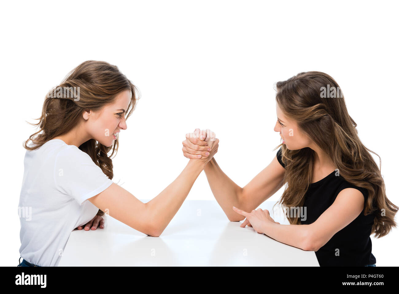 side view of angry twins armwrestling at table isolated on white Stock ...
