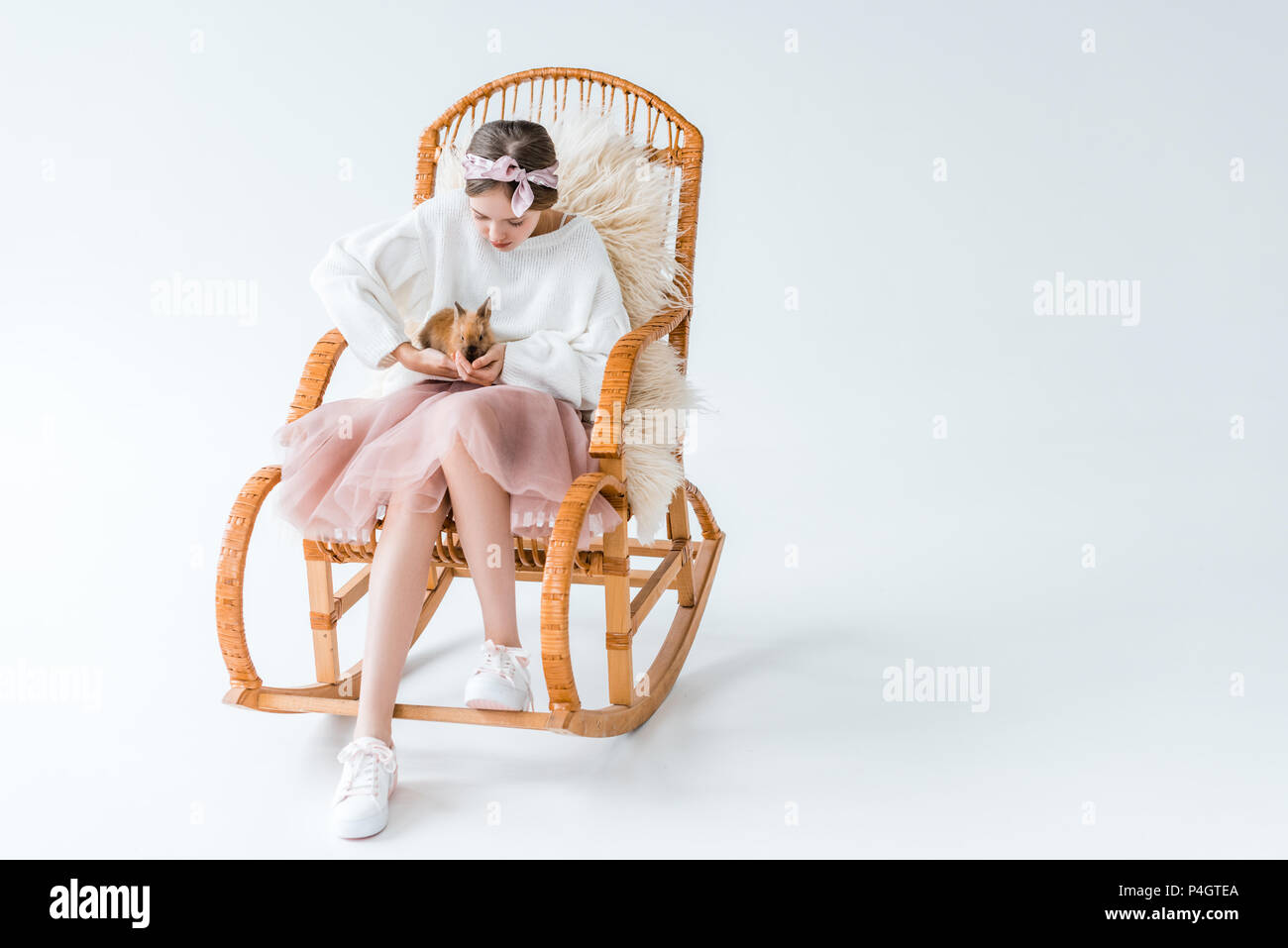 adorable girl holding furry rabbit while sitting on rocking chair ...