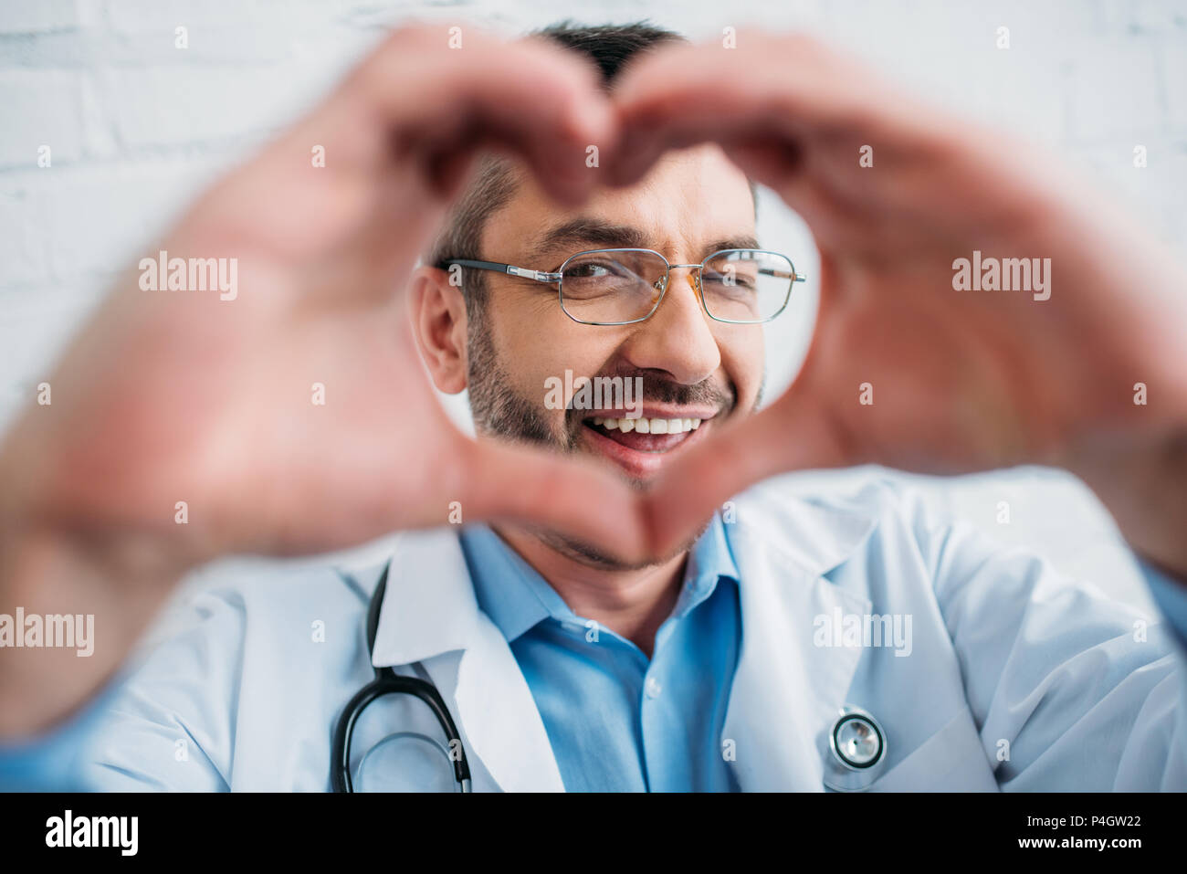 happy handsome doctor showing heart sign with hands Stock Photo - Alamy