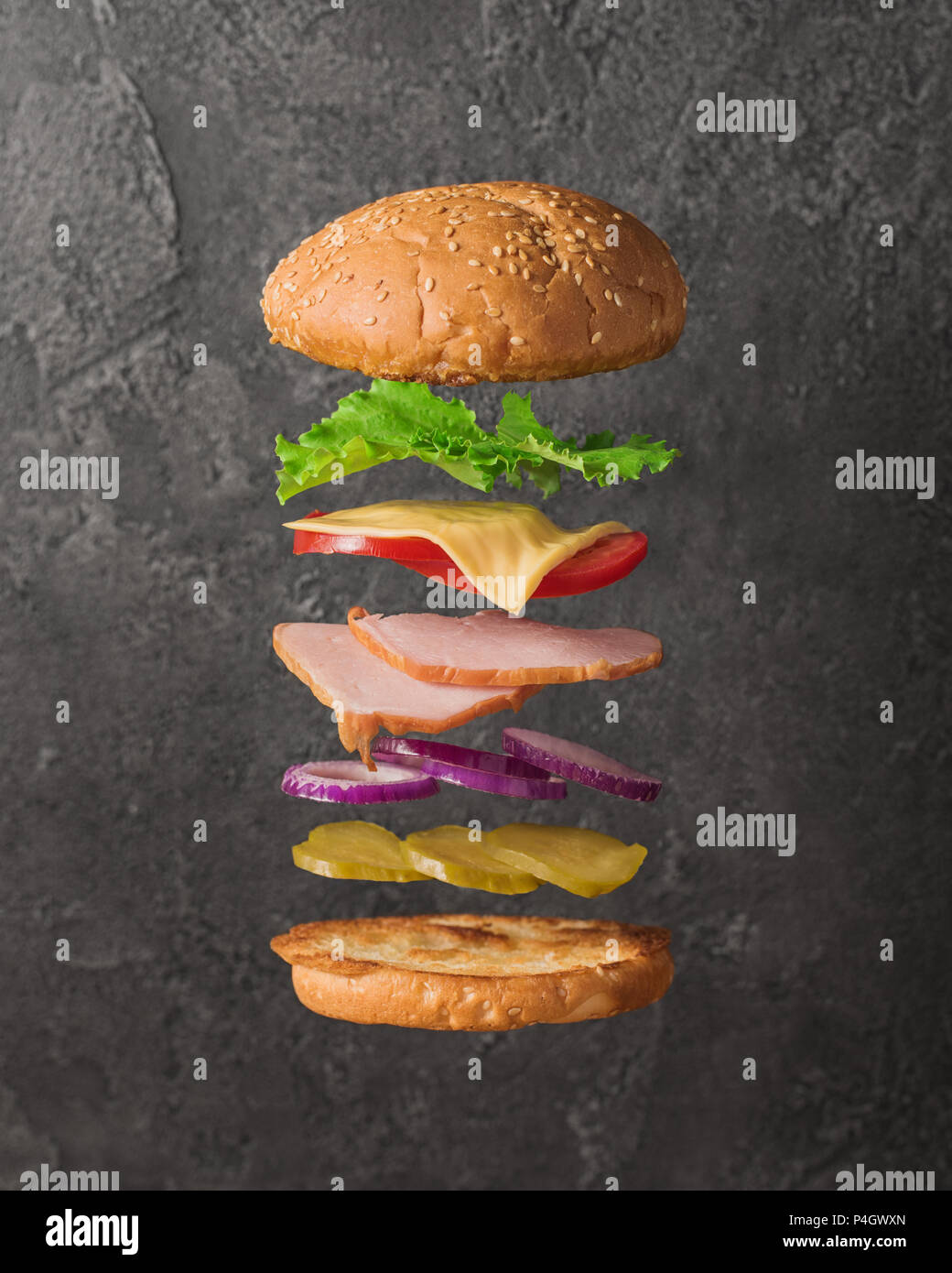 Fresh sandwich with flying ingredients isolated on concrete background ...