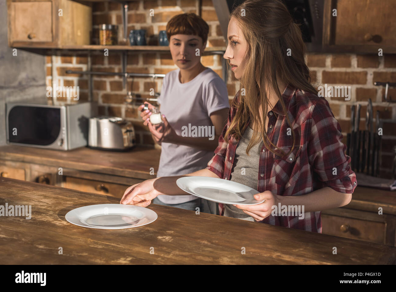 women making table setting for dinner on kitchen Stock Photo - Alamy