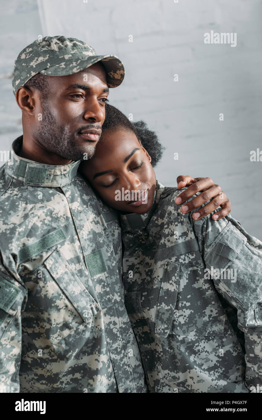 Woman and man in army uniform hugging at home Stock Photo - Alamy