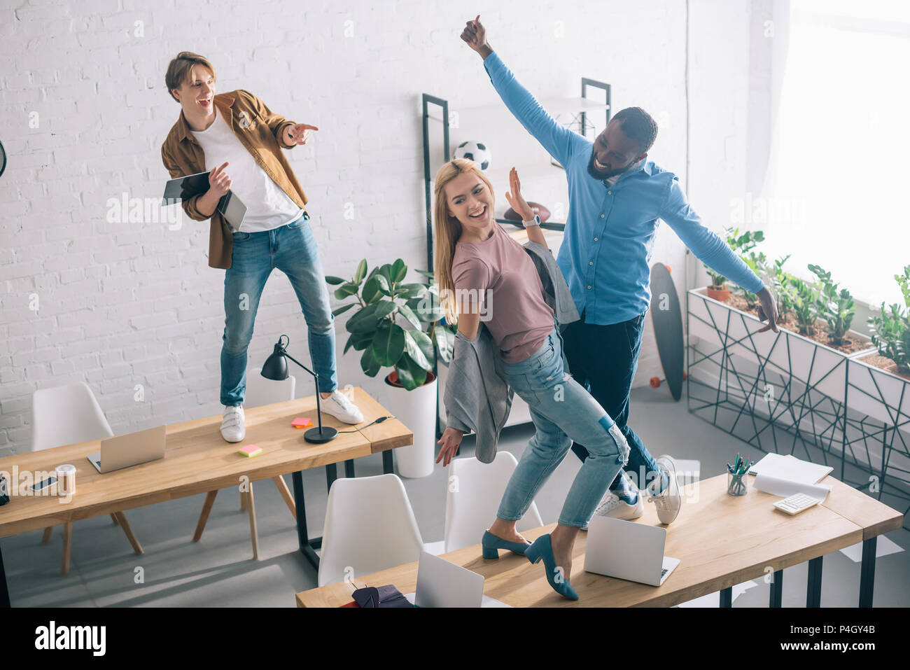 high angle view of happy multiethnic business colleagues dancing and ...