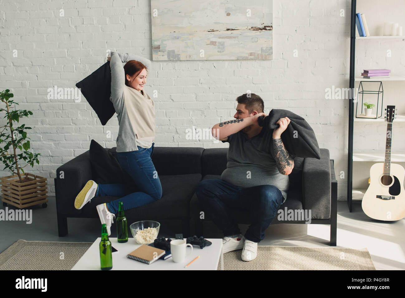 boyfriend and girlfriend fighting with pillows in living room Stock ...
