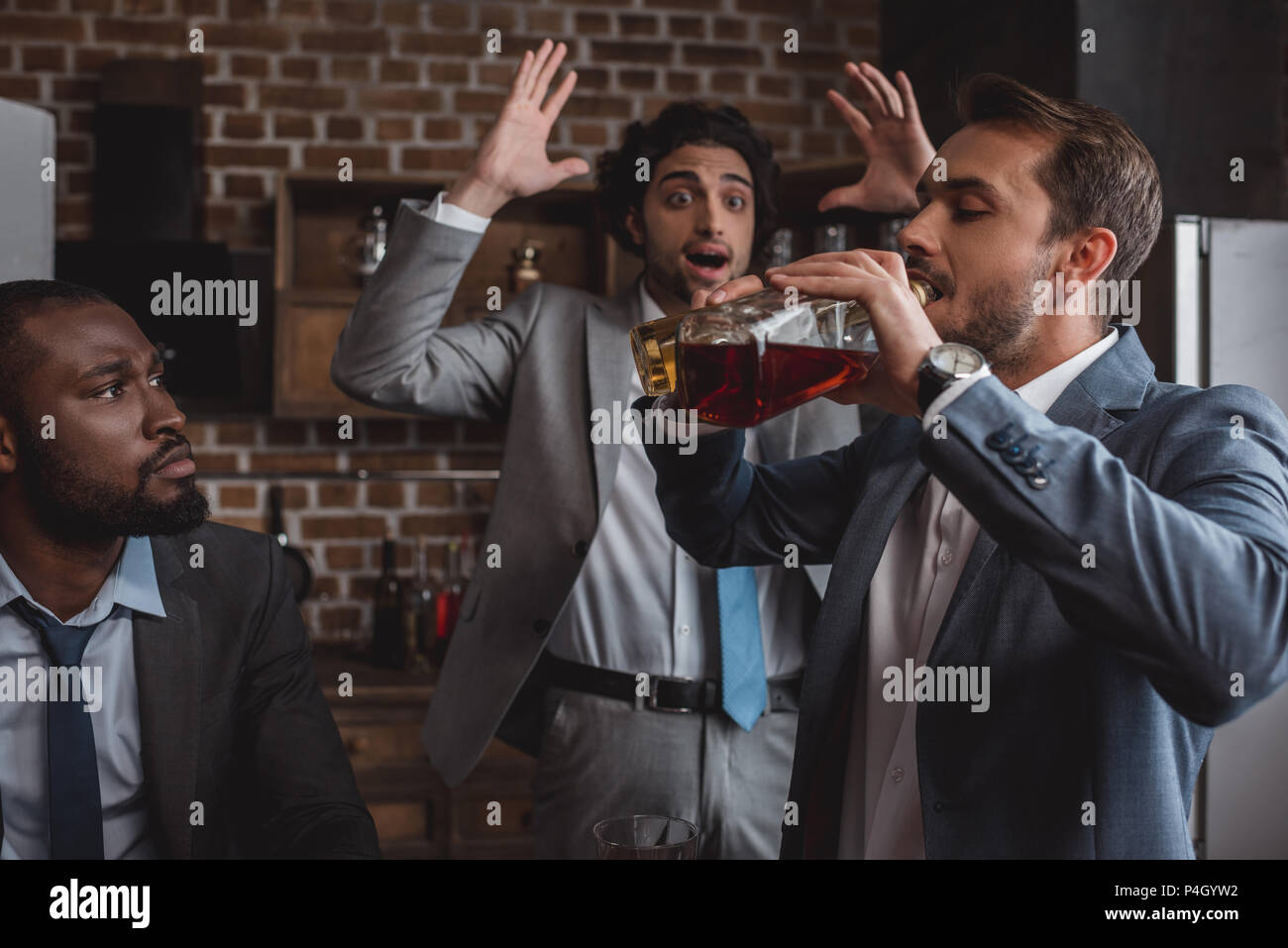 multiethnic businessmen looking at friend drinking alcohol beverages ...