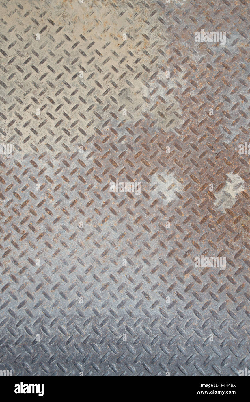 Closeup of a distressed, mottled, gungy industrial diamondplate ...