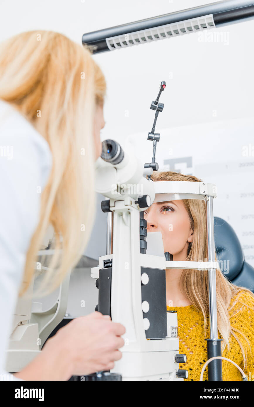 optician examining patient through slit lamp in clinic Stock Photo - Alamy