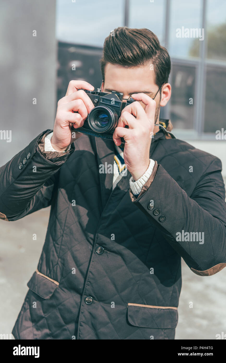 stylish young man with camera photographing on street Stock Photo - Alamy
