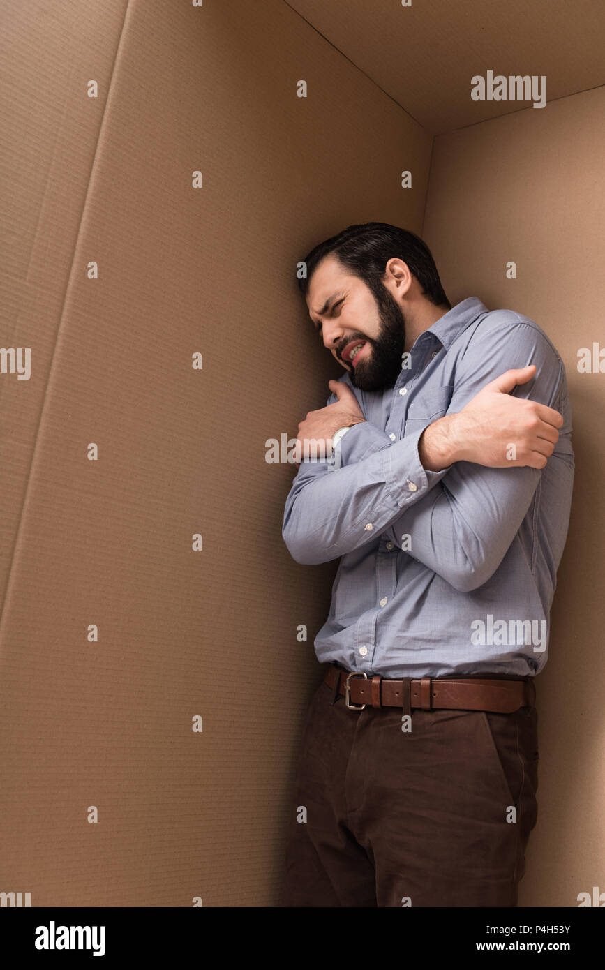 depressed crying man and huging himself in cardboard box Stock Photo ...