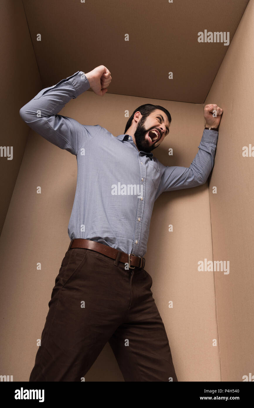 angry man yelling in cardboard box Stock Photo - Alamy